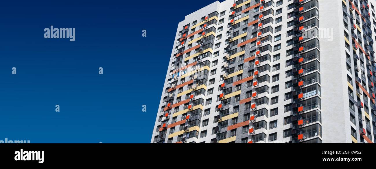 New block of flats building on blue background Stock Photo - Alamy