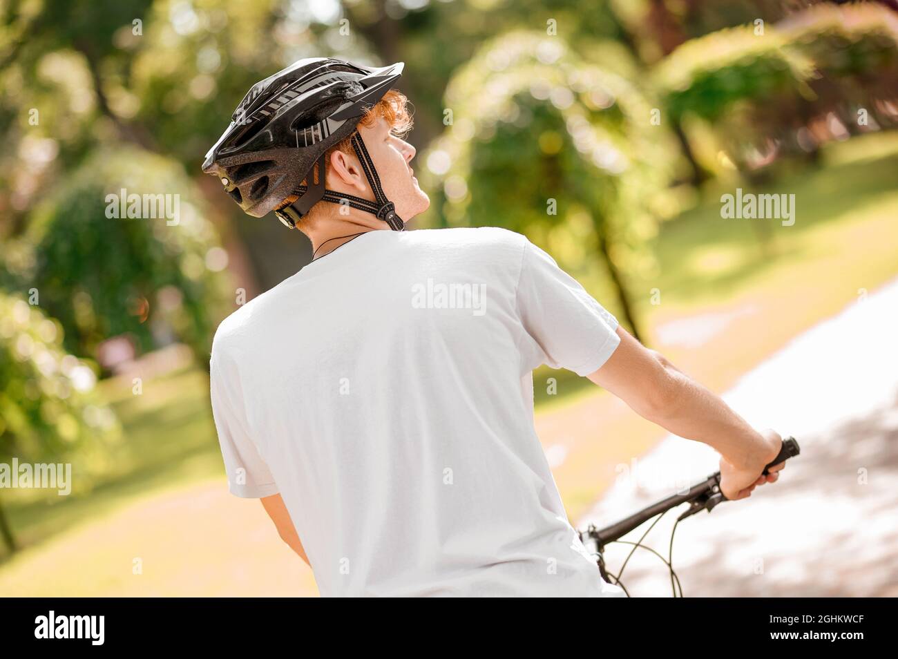 Back view of guy in helmet on bicycle Stock Photo - Alamy