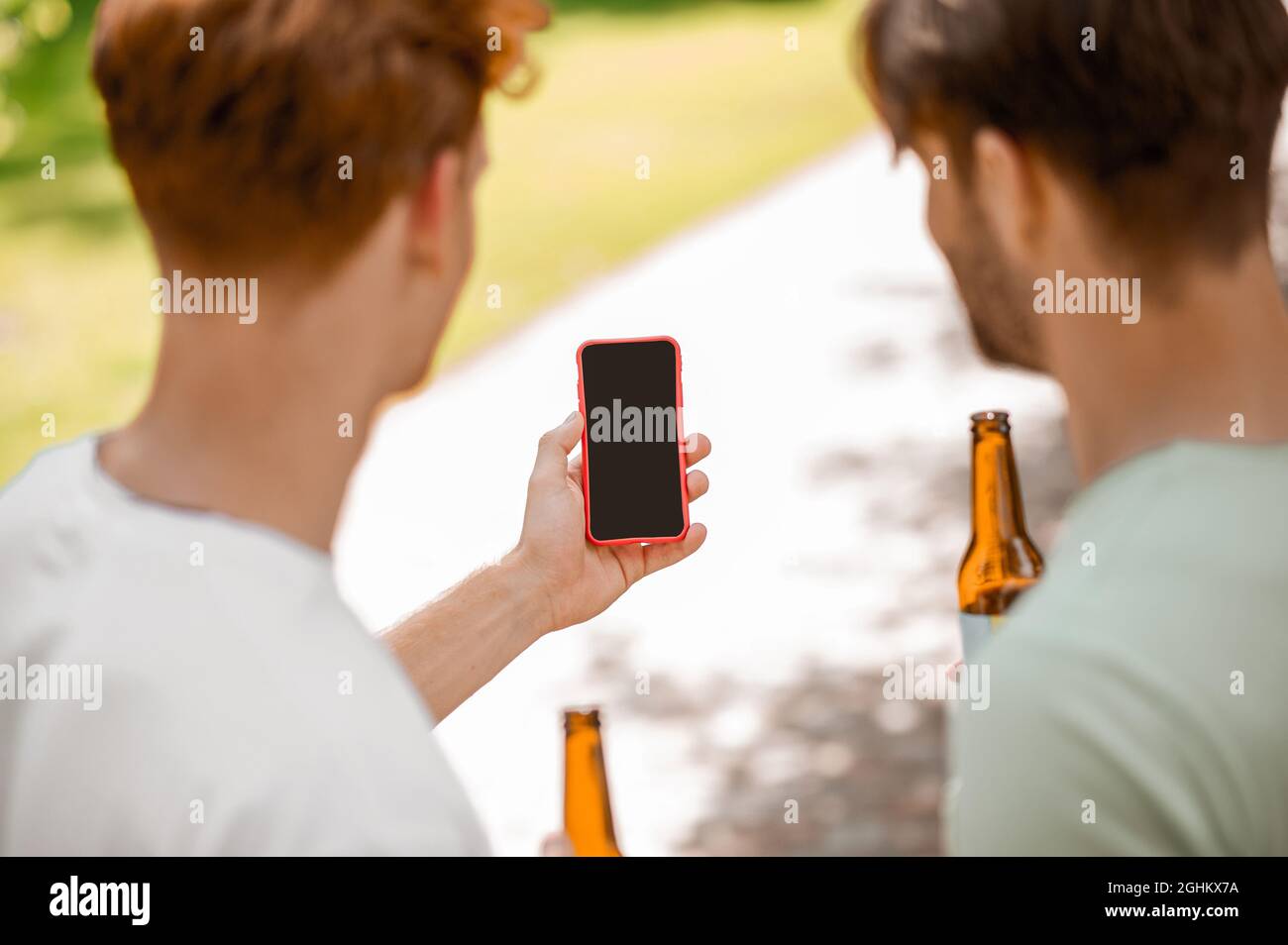 Back view of guys looking at smartphone Stock Photo - Alamy