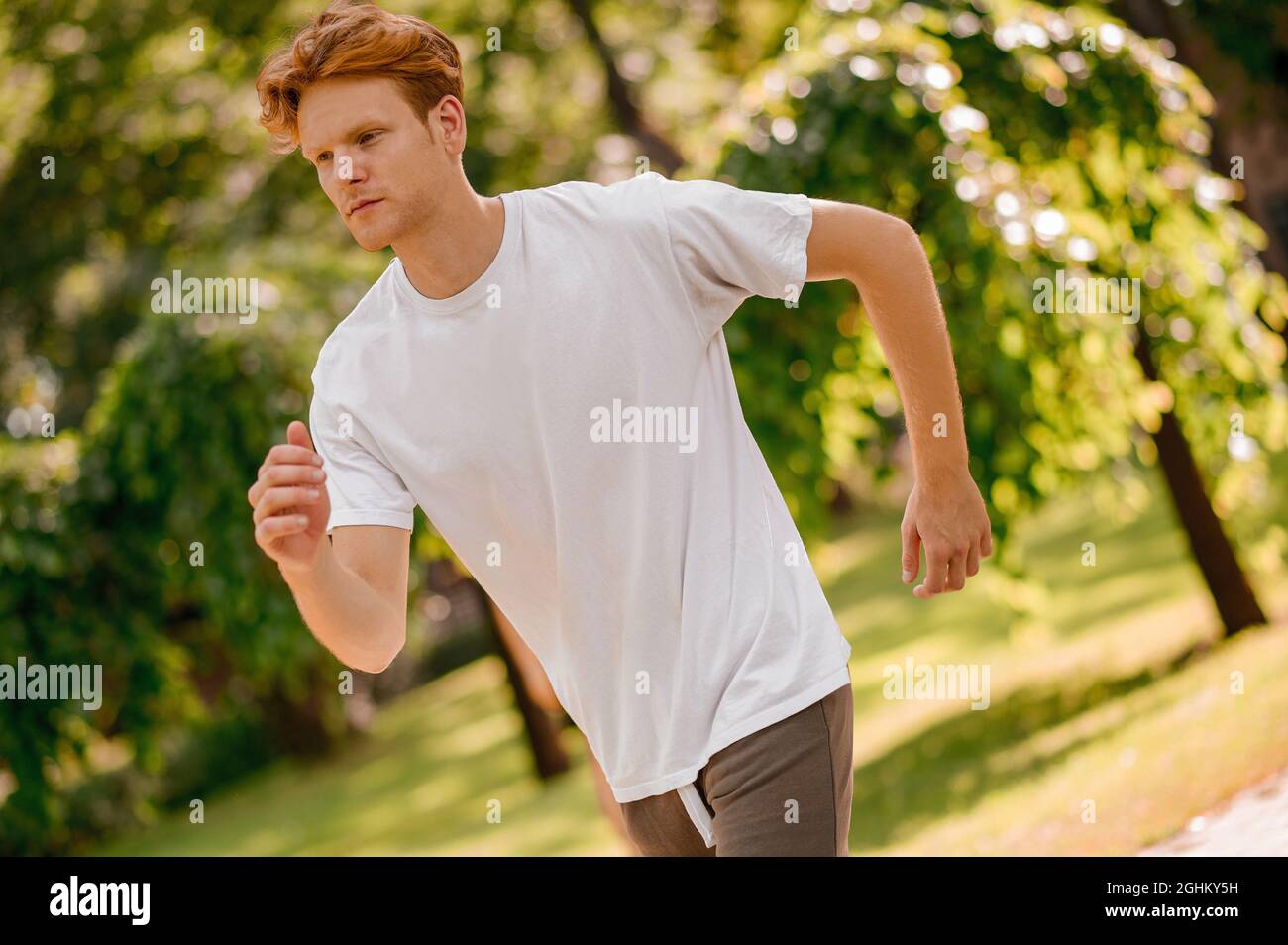 Ginger focused guy jogging in park Stock Photo - Alamy