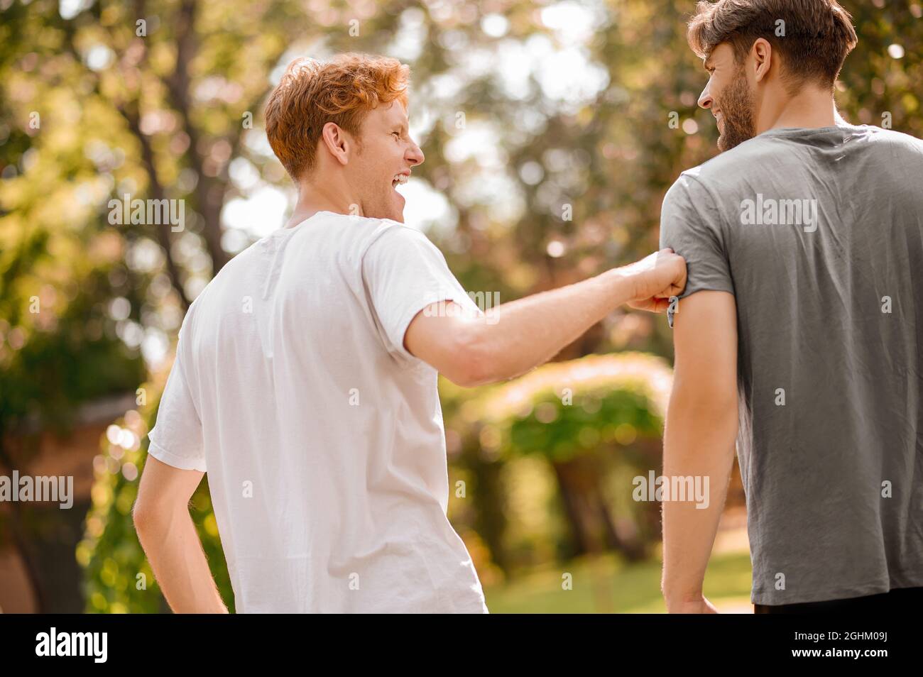 Ginger guy friendly fist touching friends shoulder Stock Photo - Alamy
