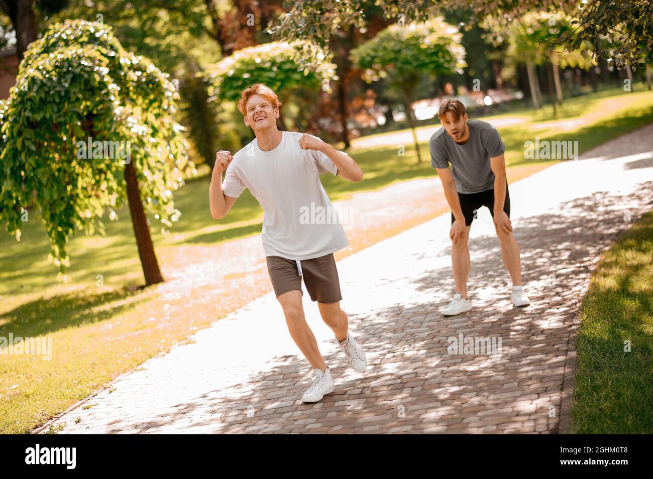 Happy ginger guy running in front and friend Stock Photo - Alamy