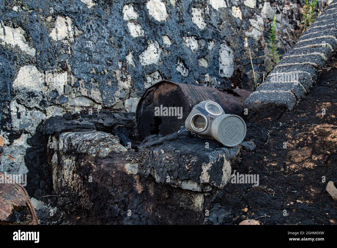 Weathered metal drum, in tar raft with gas mask Stock Photo - Alamy