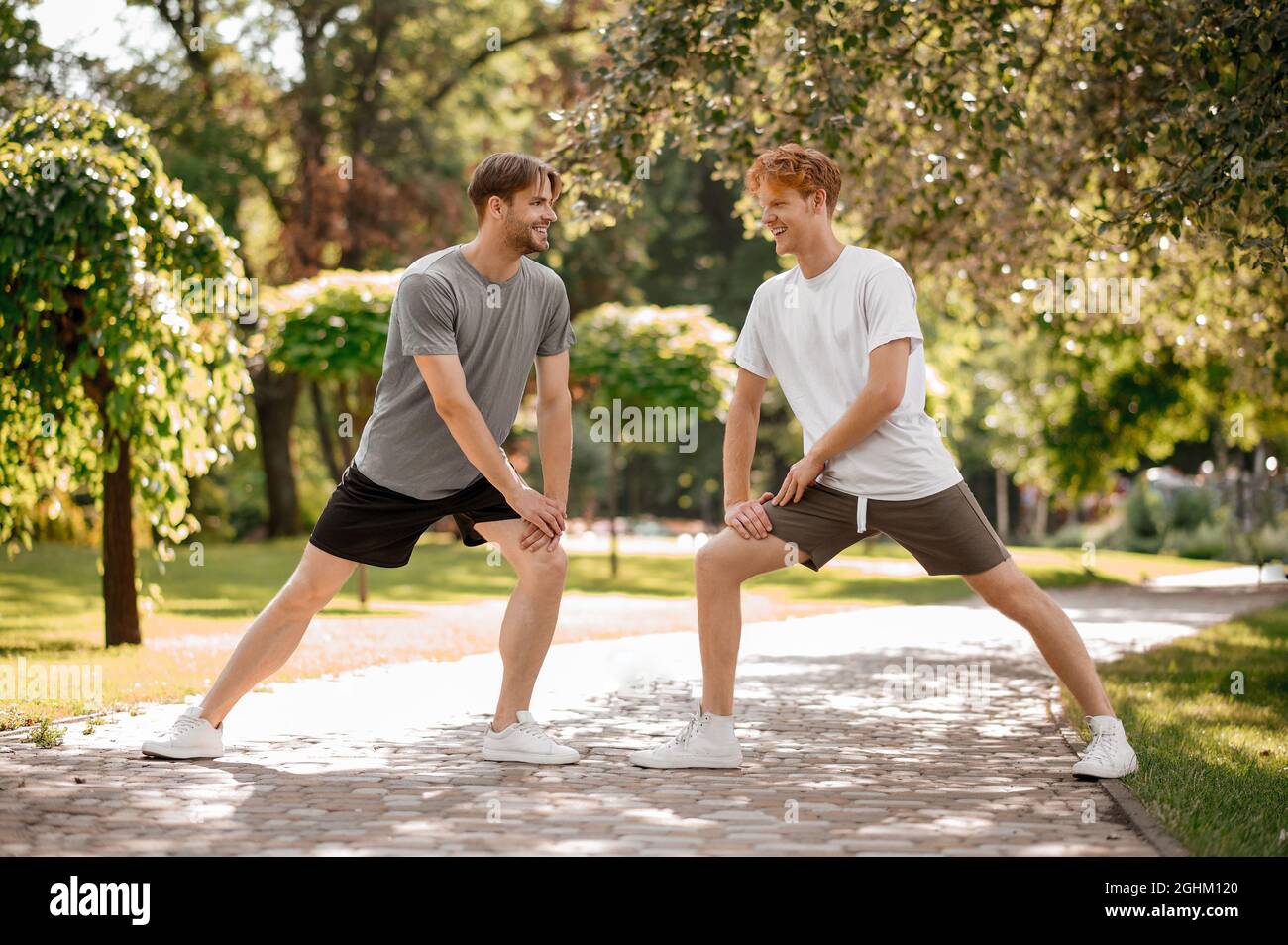 Two friends opposite each other doing stretching exercise Stock Photo ...