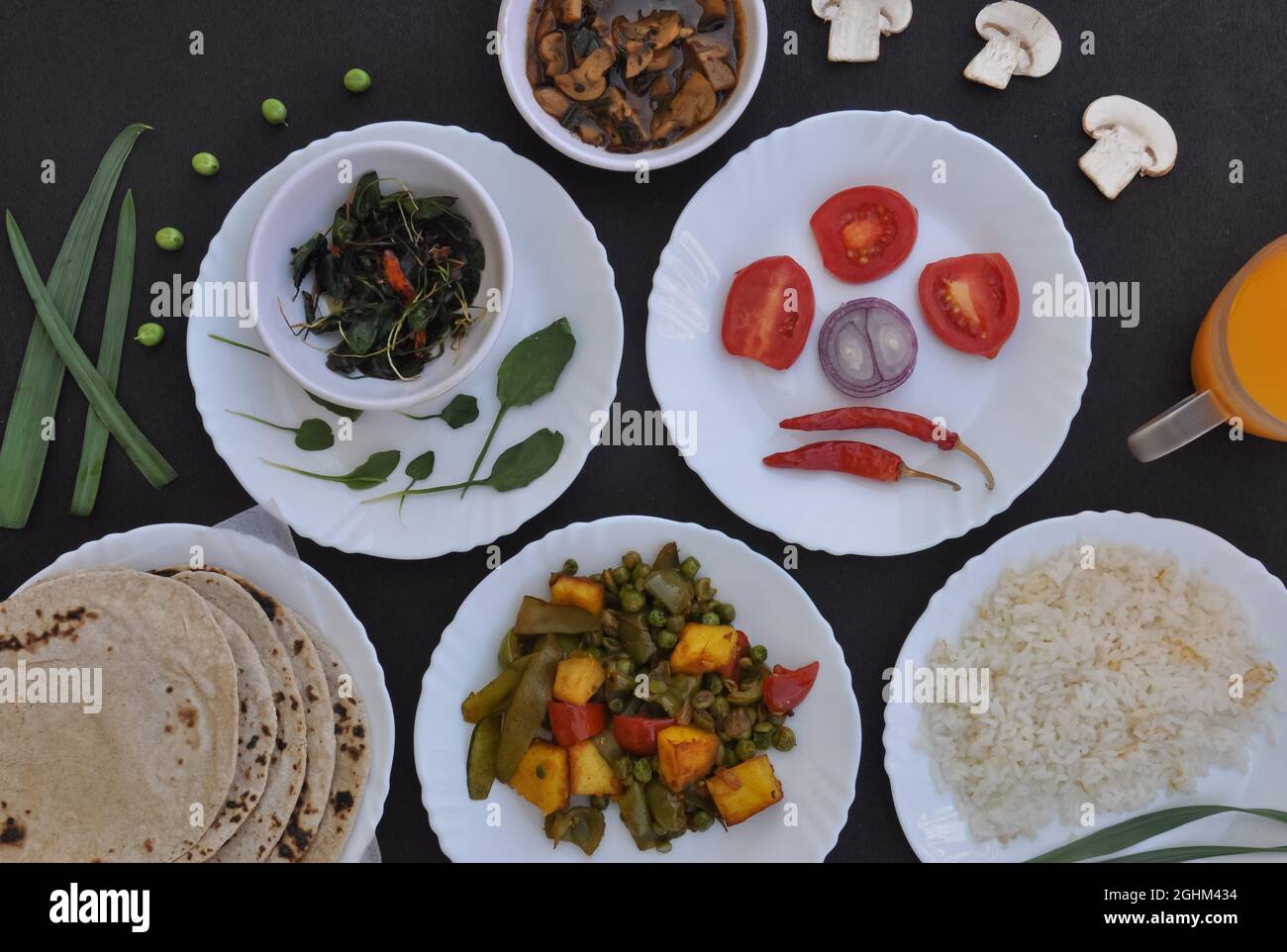 Indian Food: Overhead view of mushroom soup, saag (greens), salad, roti ...
