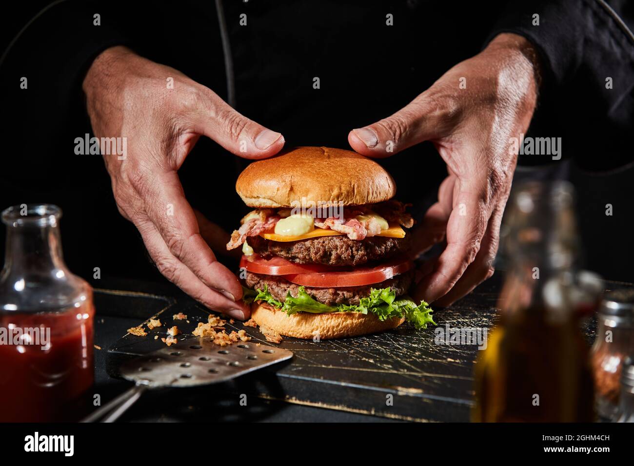 Gourmet double-decker beef burger with bacon and cheese over succulent ...