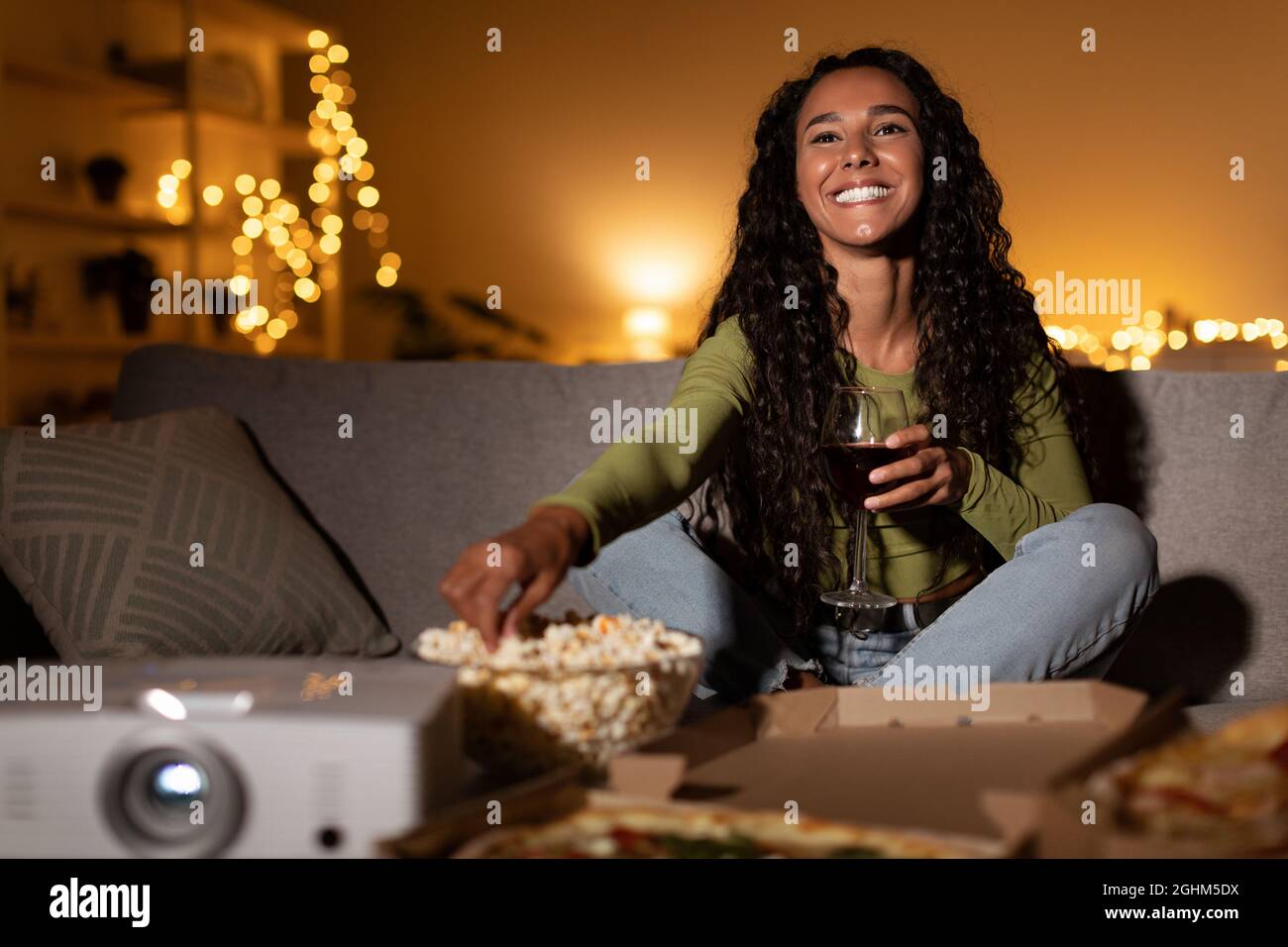 Happy Woman Watching Movie Using Home Cinema Projector Sitting Indoors ...