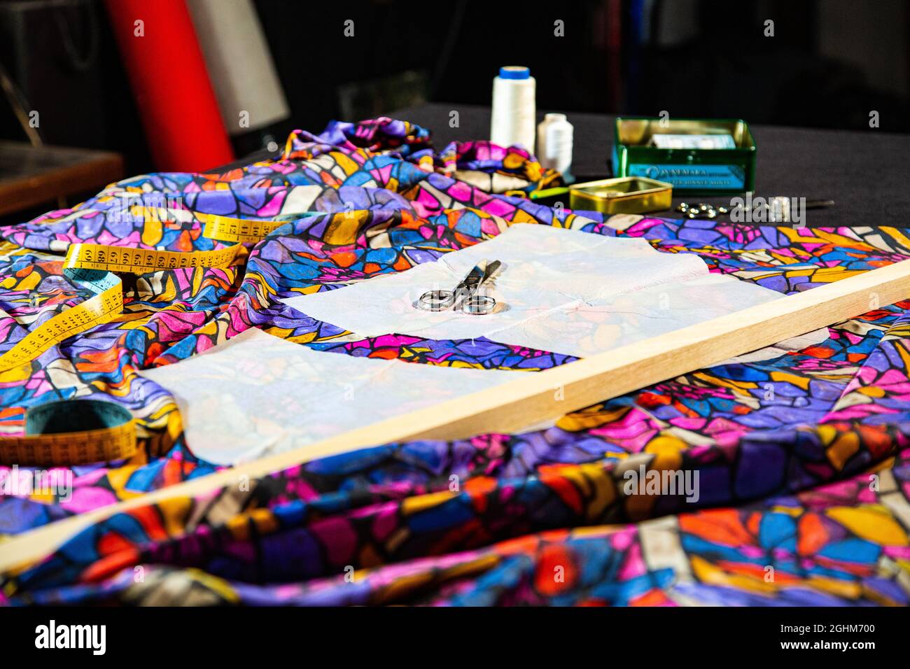 Sewing workshop with a table full of fabrics of various colors and ...