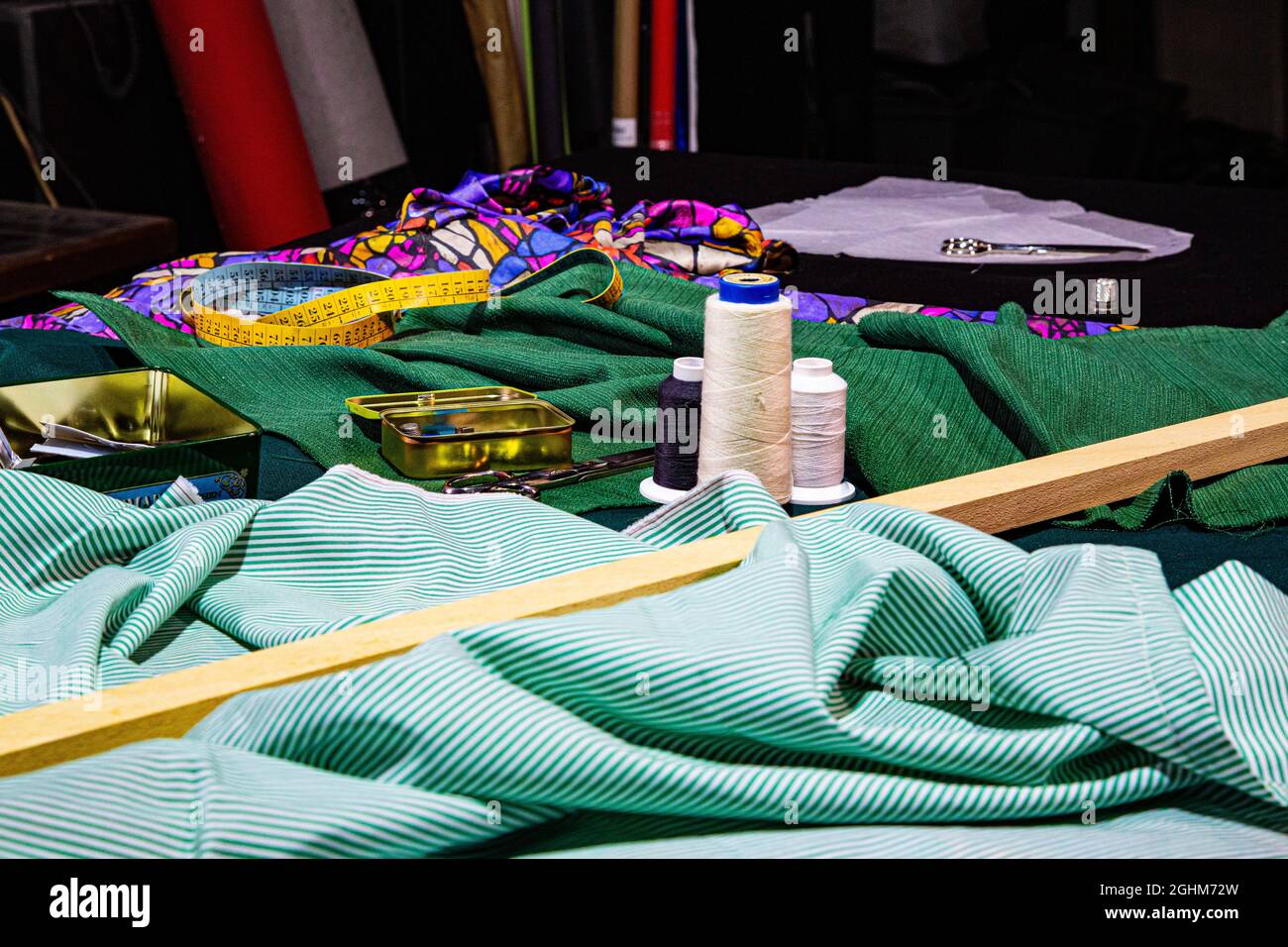 Sewing workshop with a table full of fabrics of various colors and ...