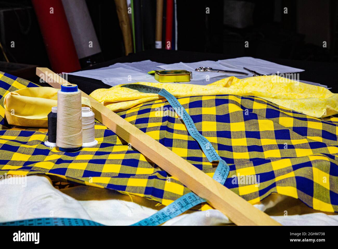 Sewing workshop with a table full of fabrics of various colors and ...