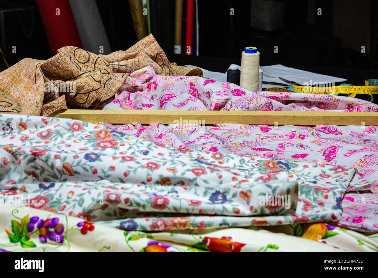 Sewing workshop with a table full of fabrics of various colors and ...