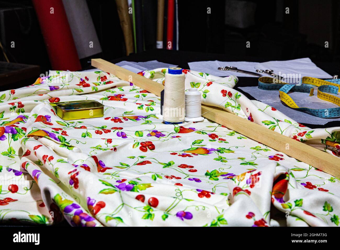 Sewing workshop with a table full of fabrics of various colors and ...