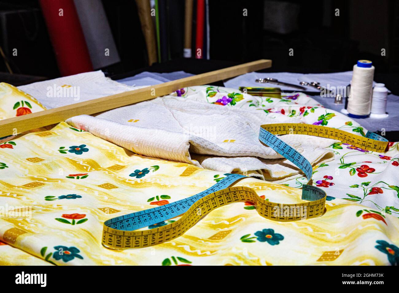 Sewing workshop with a table full of fabrics of various colors and ...