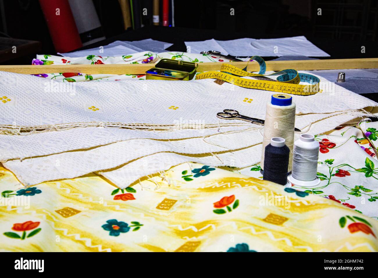 Sewing workshop with a table full of fabrics of various colors and ...