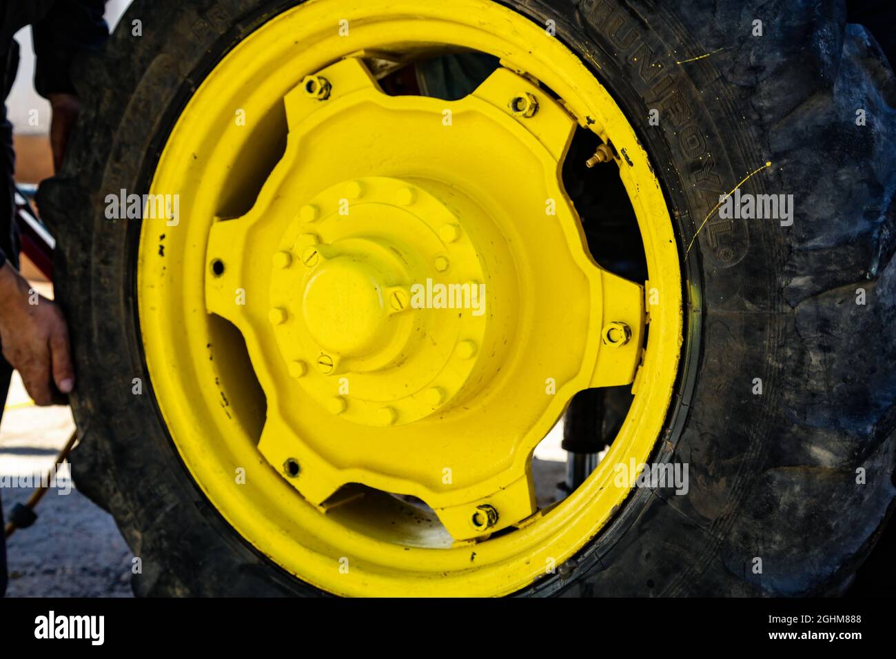 Putting a yellow tractor wheel Stock Photo - Alamy