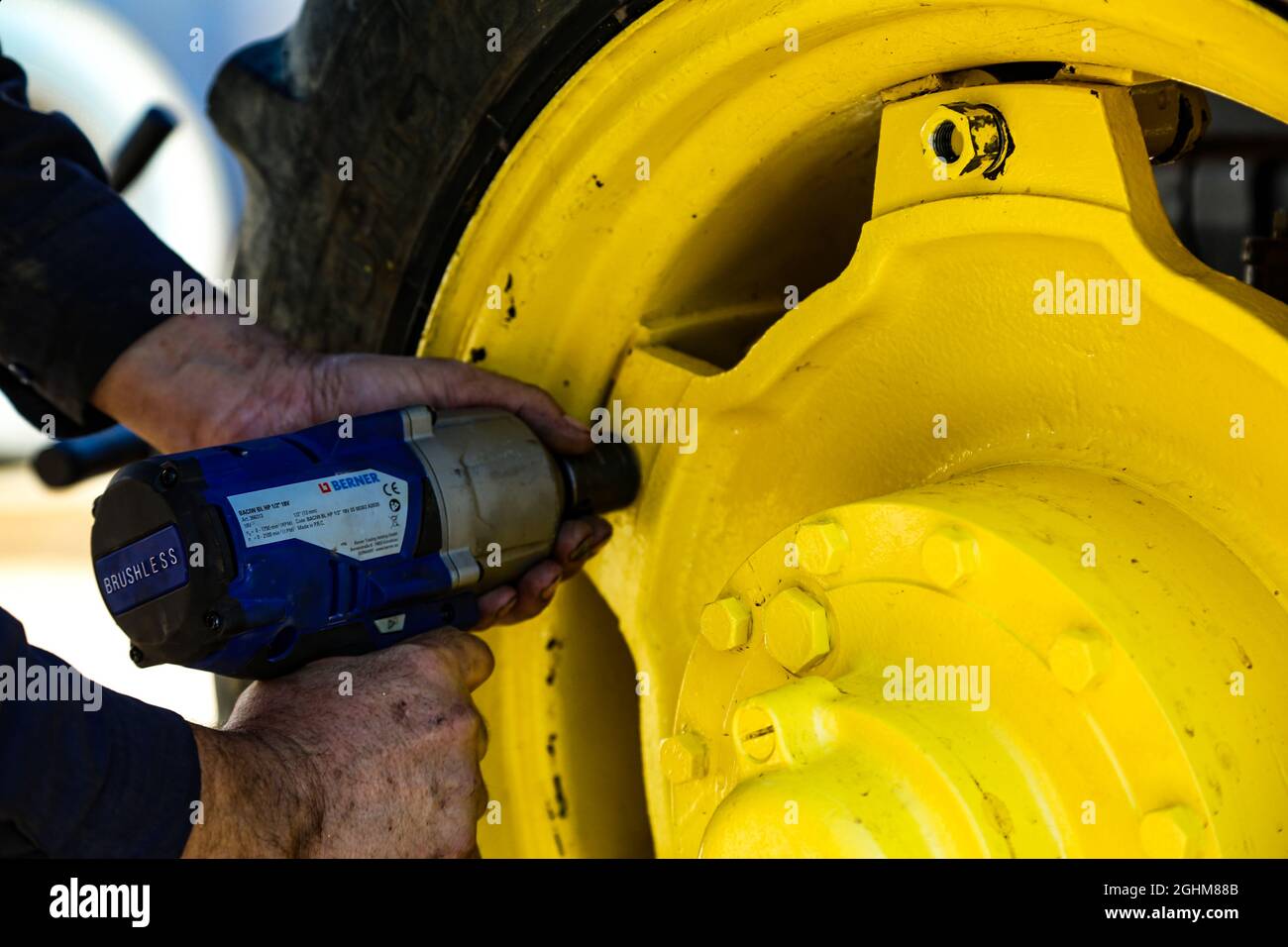 Putting a yellow tractor wheel Stock Photo - Alamy