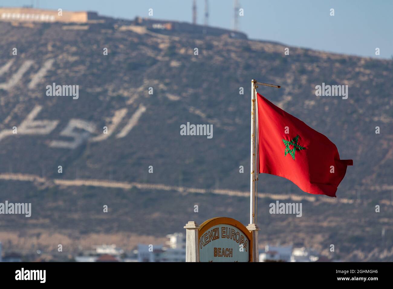 Close up shot of a Moroccan flag in Agadir, Morocco with beautiful hill ...