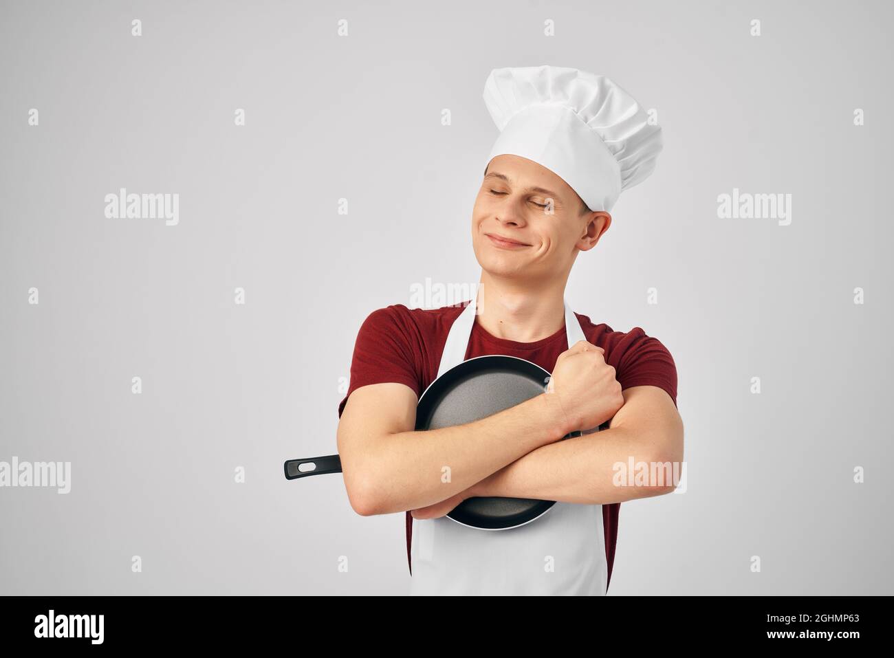 man in white apron chef cooking light background Stock Photo - Alamy