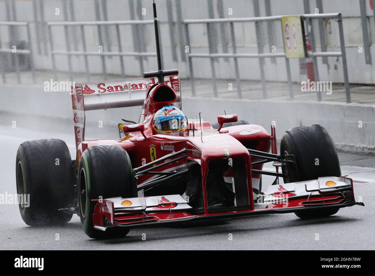 Fernando Alonso (ESP) Ferrari F138 leaves the pits with something ...