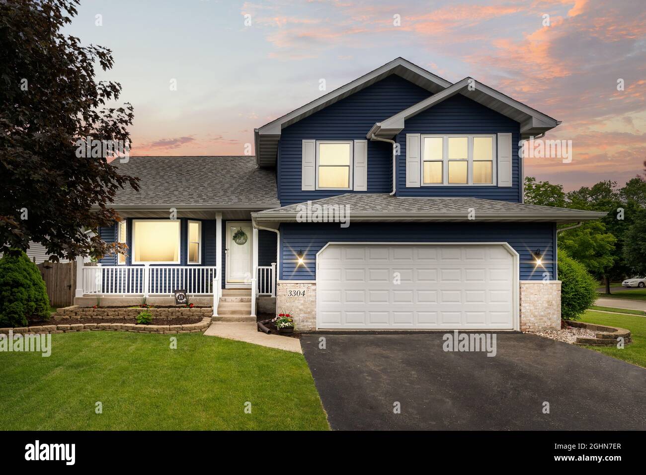 Exterior of a suburban home with blue siding, a white front porch, and ...