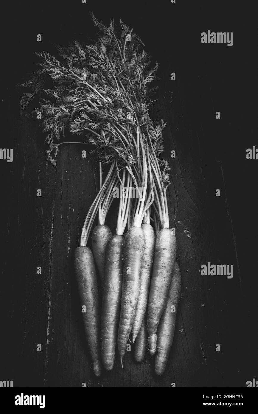 Top view of grayscale of fresh carrots on the wooden surface Stock ...