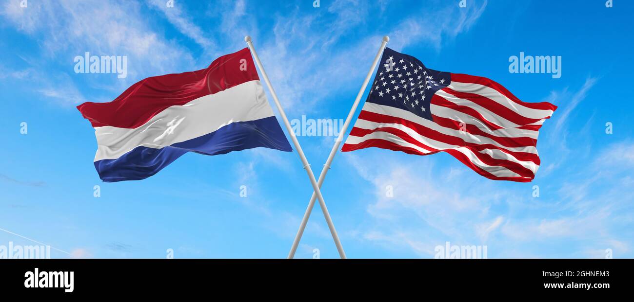 flags of USA and netherlands waving in the wind on flagpoles against ...