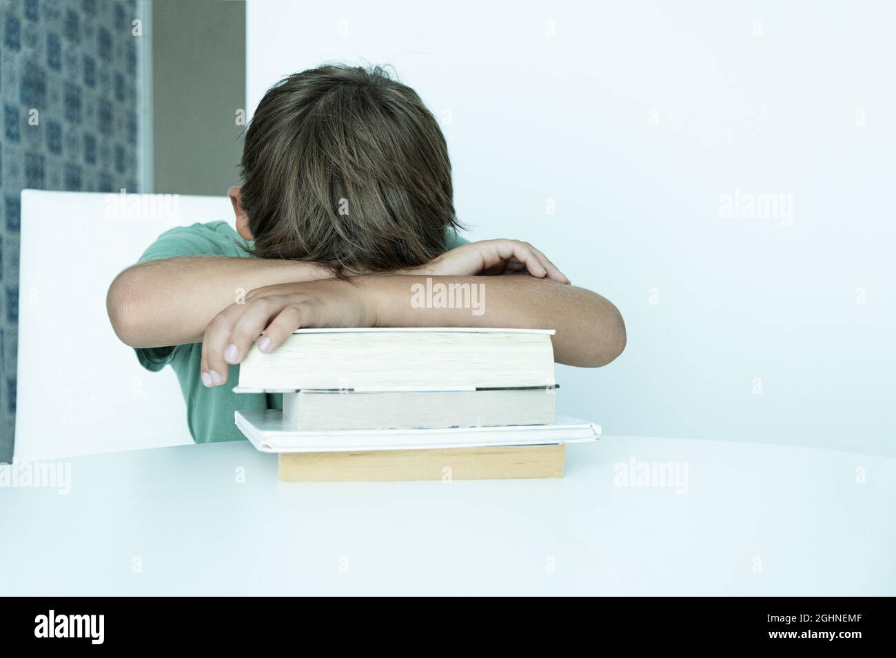 Sad boy with book does school homework. Back to school. Unhappy ...