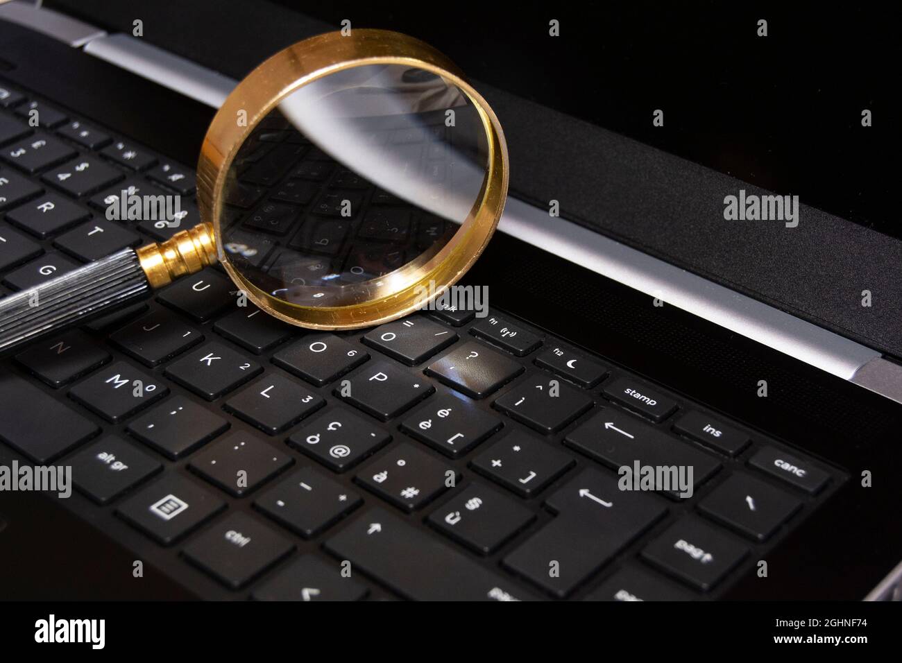 Magnifying glass on mobile laptop keybord, searching information ...