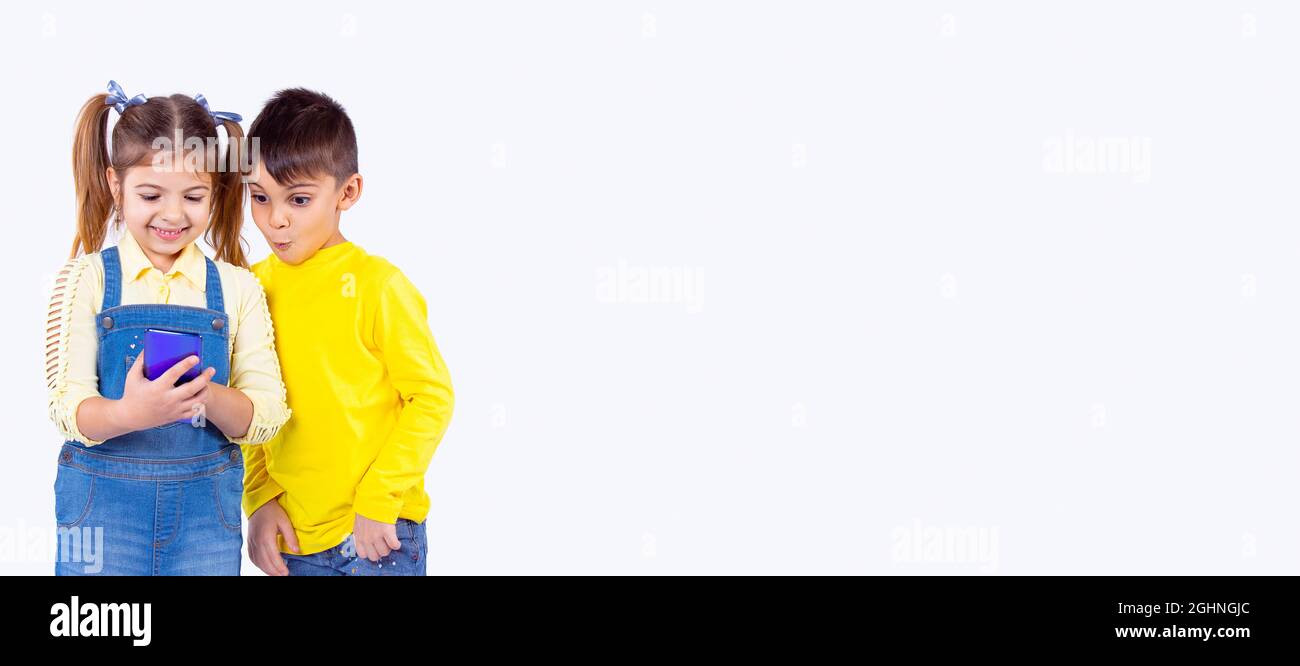 Two children smiling and surprised expression looking to screen ...