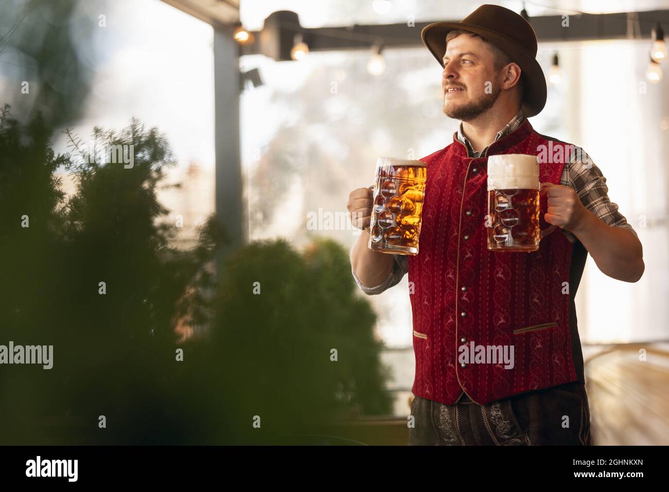 Happy smiling man, waiter in traditional Austrian or Bavarian costume ...