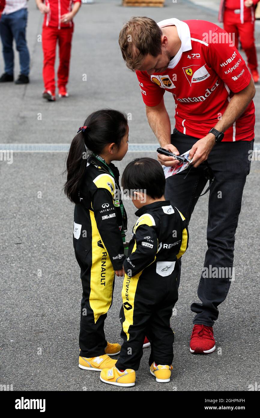 Sebastian Vettel (GER) Ferrari with young Renault Sport F1 Team fans ...