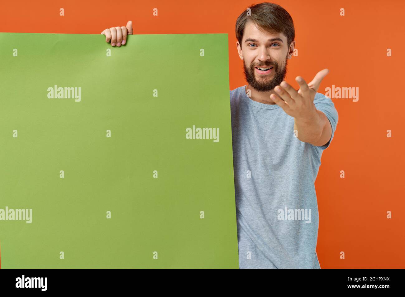 bearded man holding a green banner design orange background Stock Photo ...