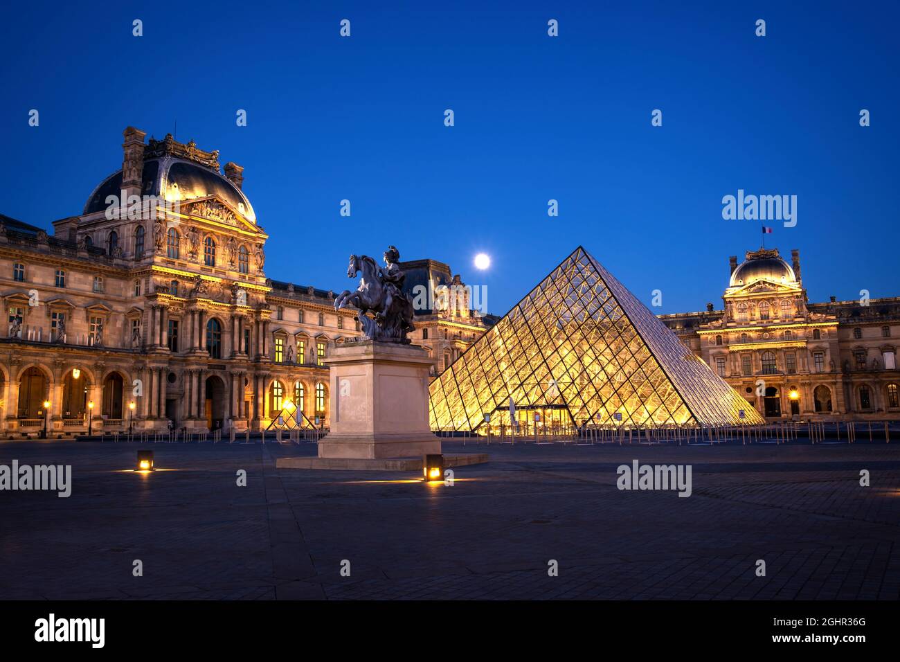 Louvre museum and the pyramid illuminated at night in Paris France ...
