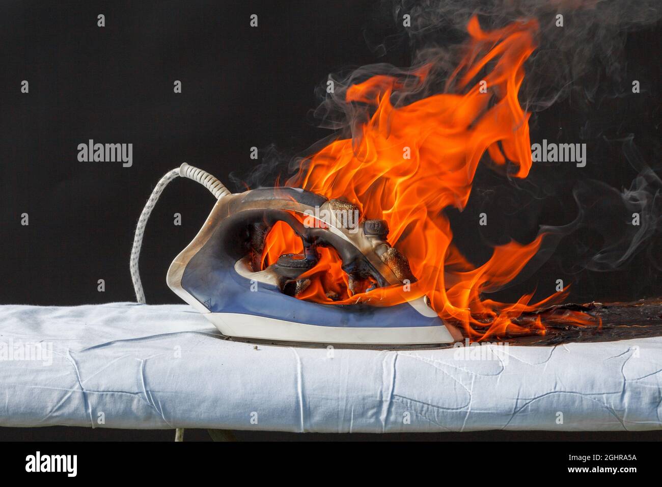 Iron in flames of fire, faulty wiring, cause of fire Stock Photo - Alamy