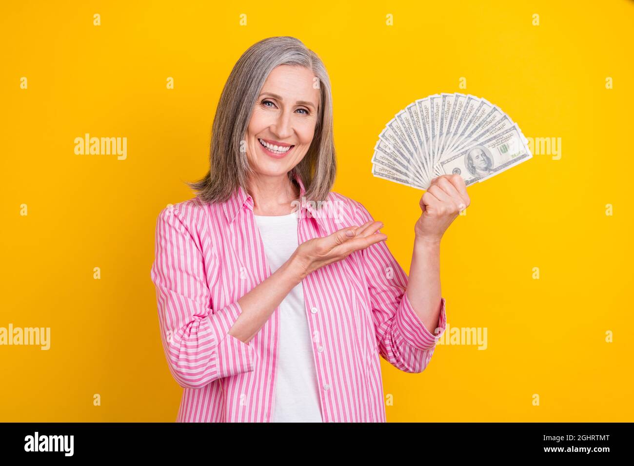 Photo of aged woman happy positive smile show hand money cash dollars ...