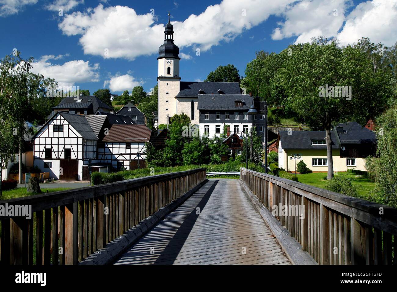 Wooden bridge over the river Saale, view to village with church ...