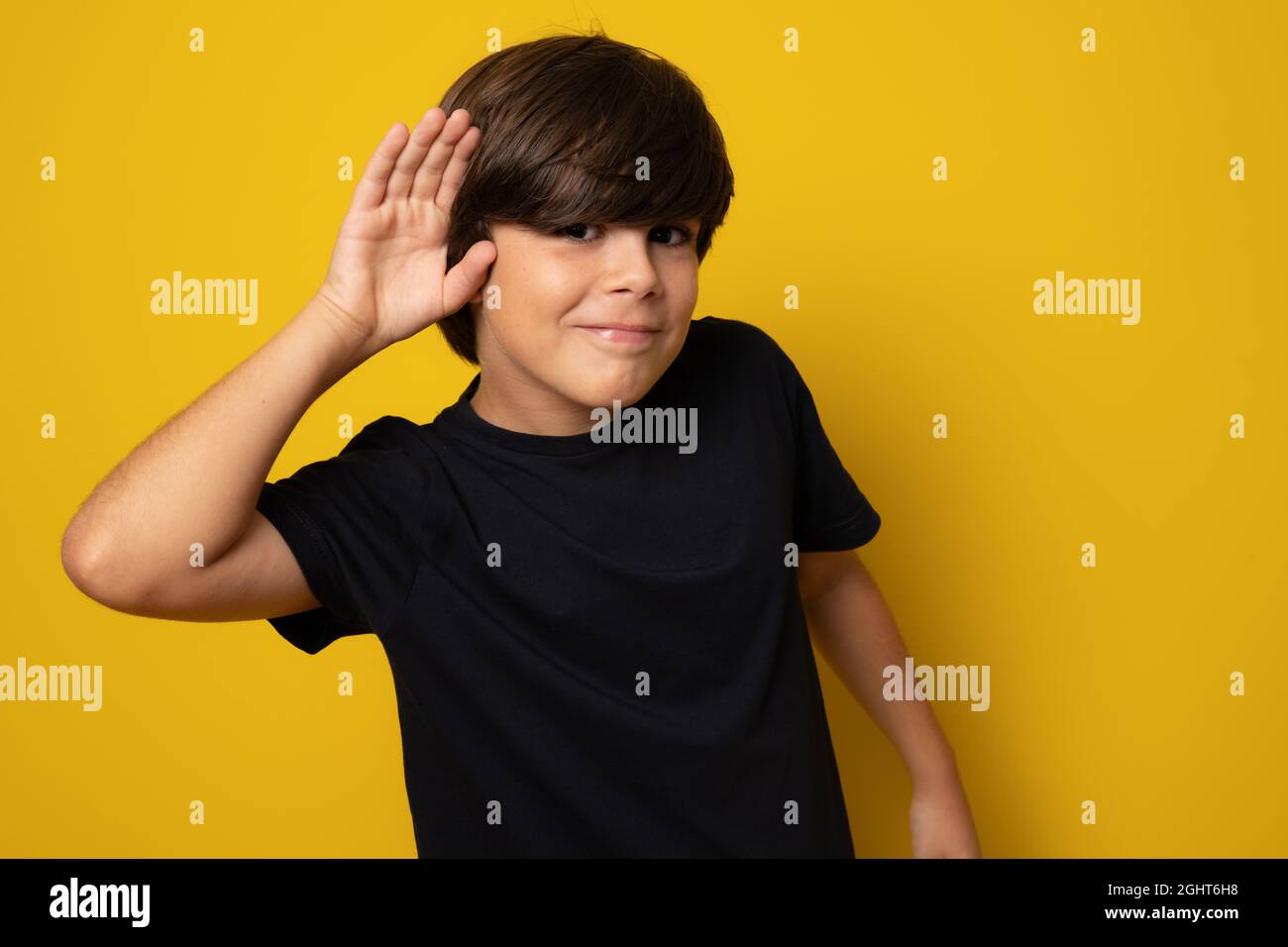 Kid listening something isolated over yellow background Stock Photo - Alamy