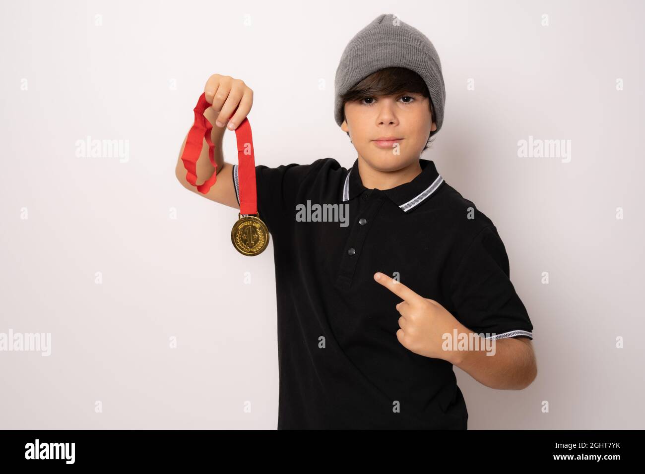Cute child boy showing his gold medal isolated over white background ...