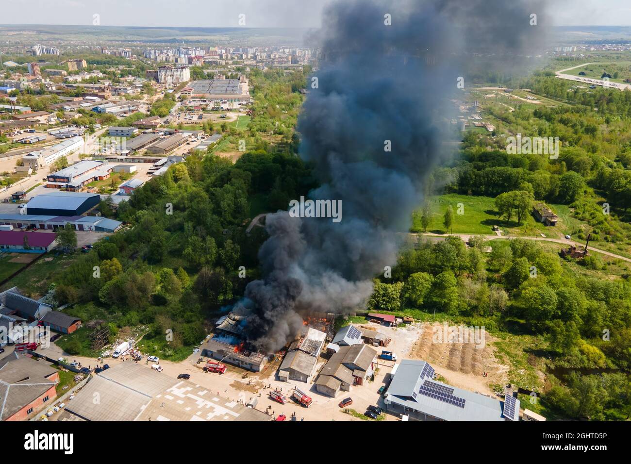 Aerial view of firefighters extinguishing ruined building on fire with ...