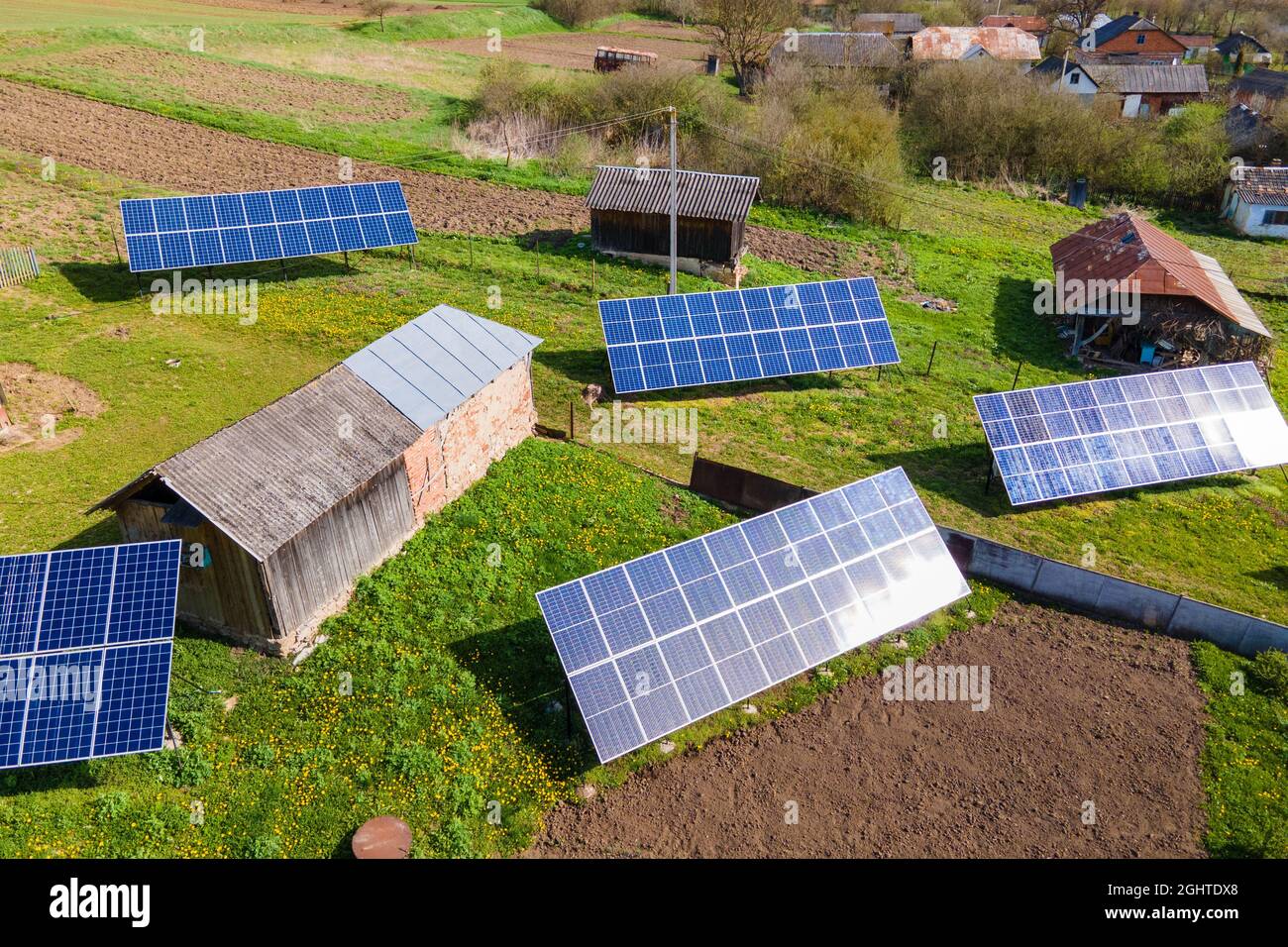 Aerial view of blue photovoltaic solar panels mounted on backyard ...