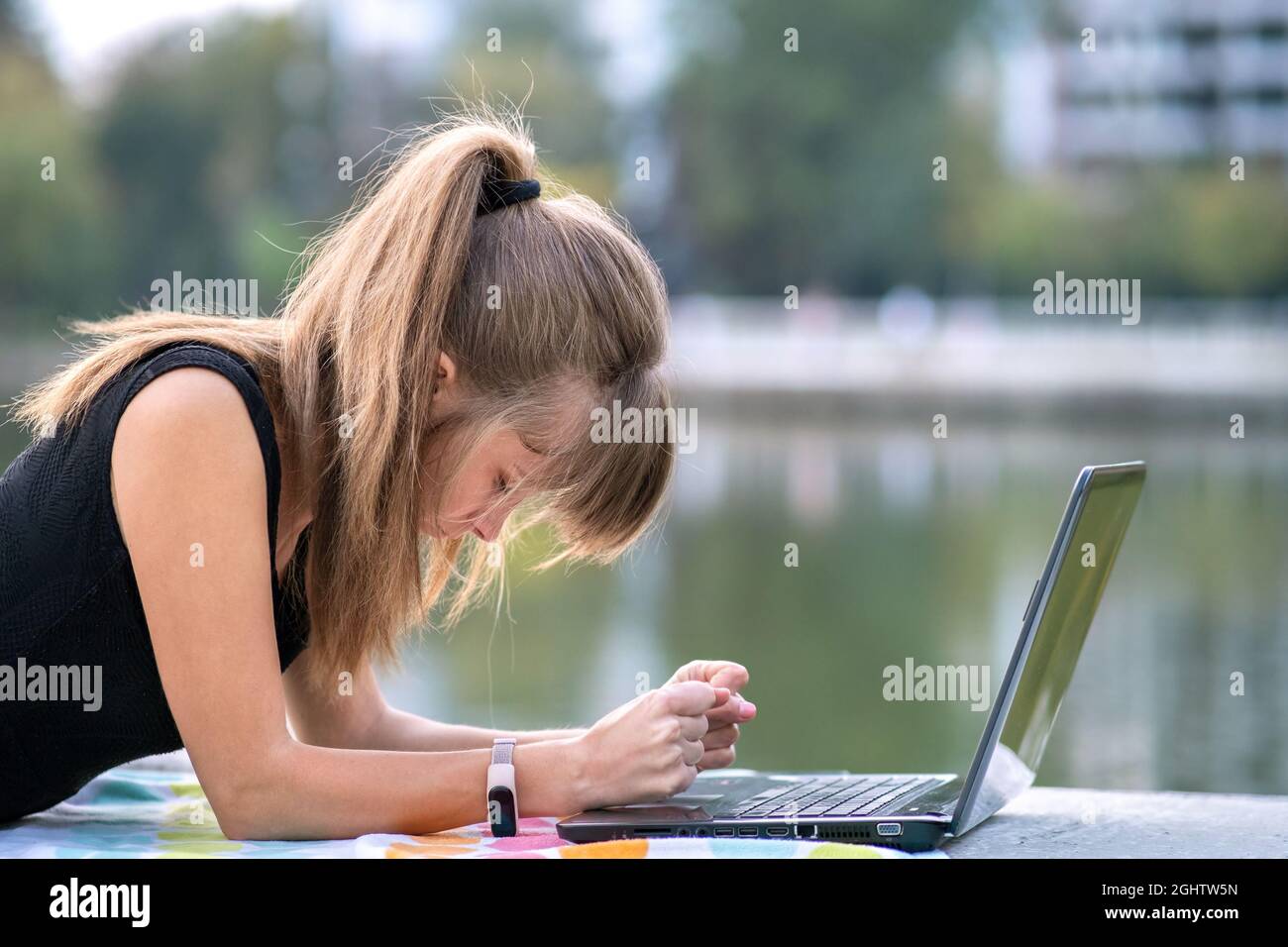 Tired female office employee working behind laptop computer lying down ...