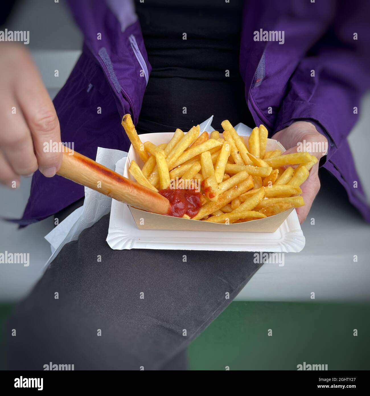 Senior woman eating traditional Danish sausage with chips, Denmark ...