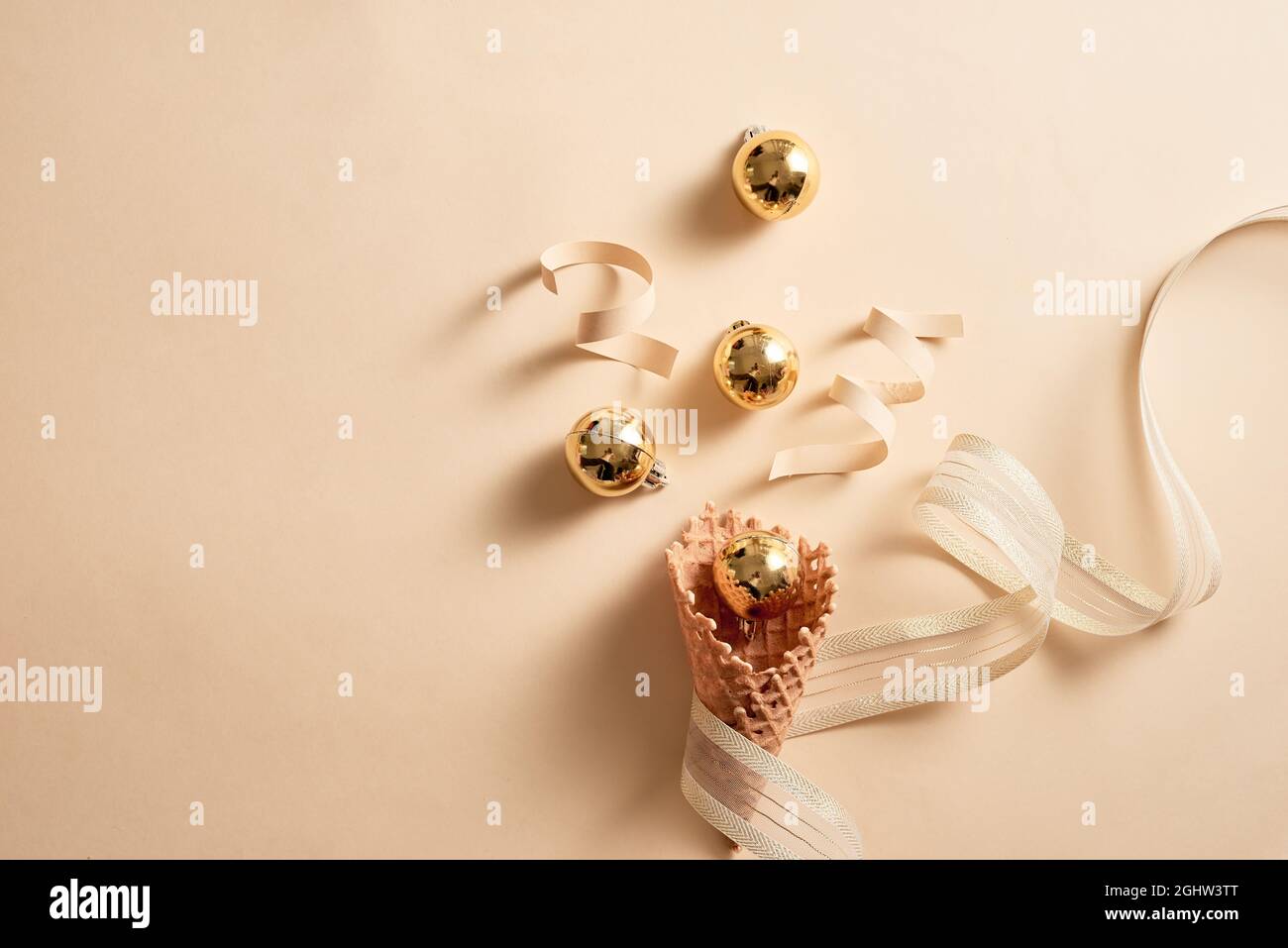 Ice cream waffle cone with ribbon and balls ornament topping. Skin ...