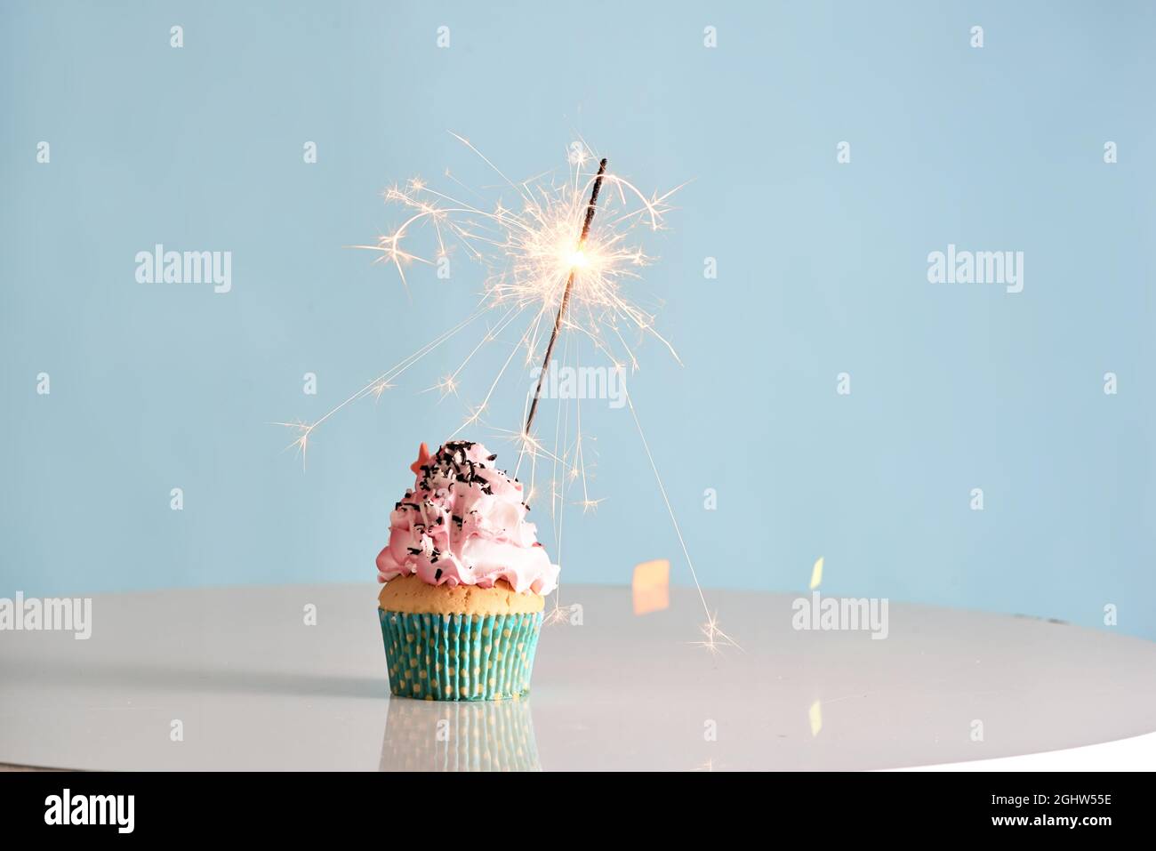 Single sparkler on cupcake blue wal Stock Photo - Alamy