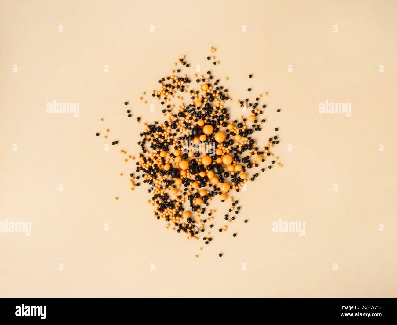 Colored background with sugar sprinkles, dots with orange and black ...