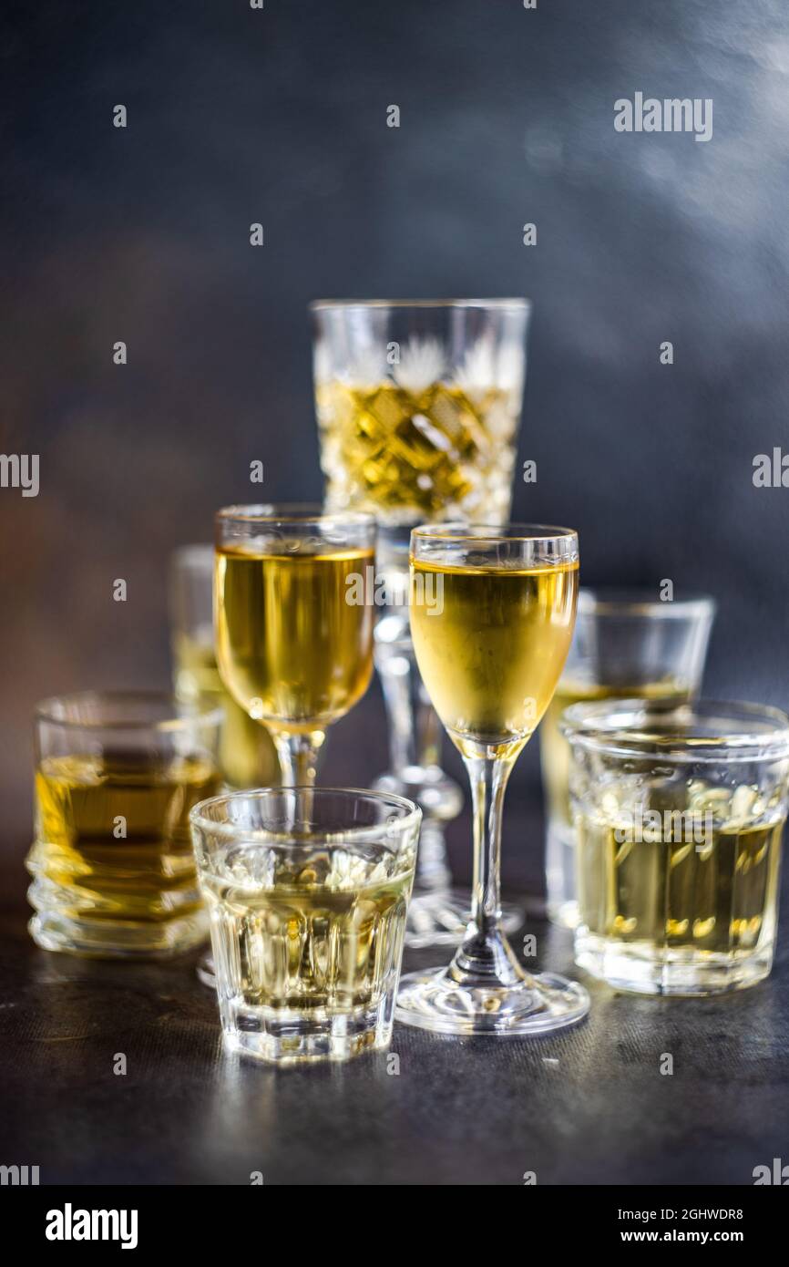 Assorted shot glasses, wine glasses and tumblers filled with ...