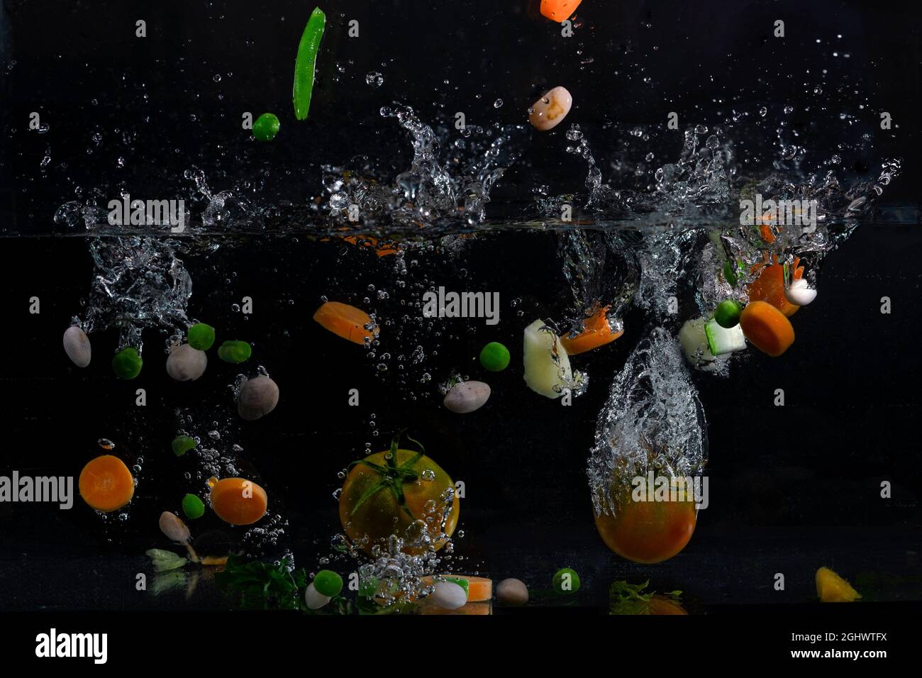 Ingredients for vegetable soup splashing in water Stock Photo - Alamy