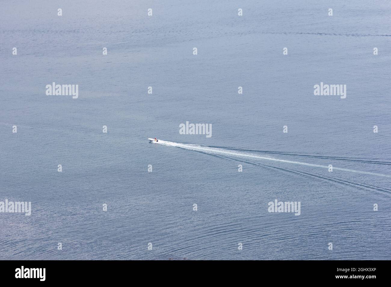 White foam wake of small boat in the ocean blue Stock Photo - Alamy