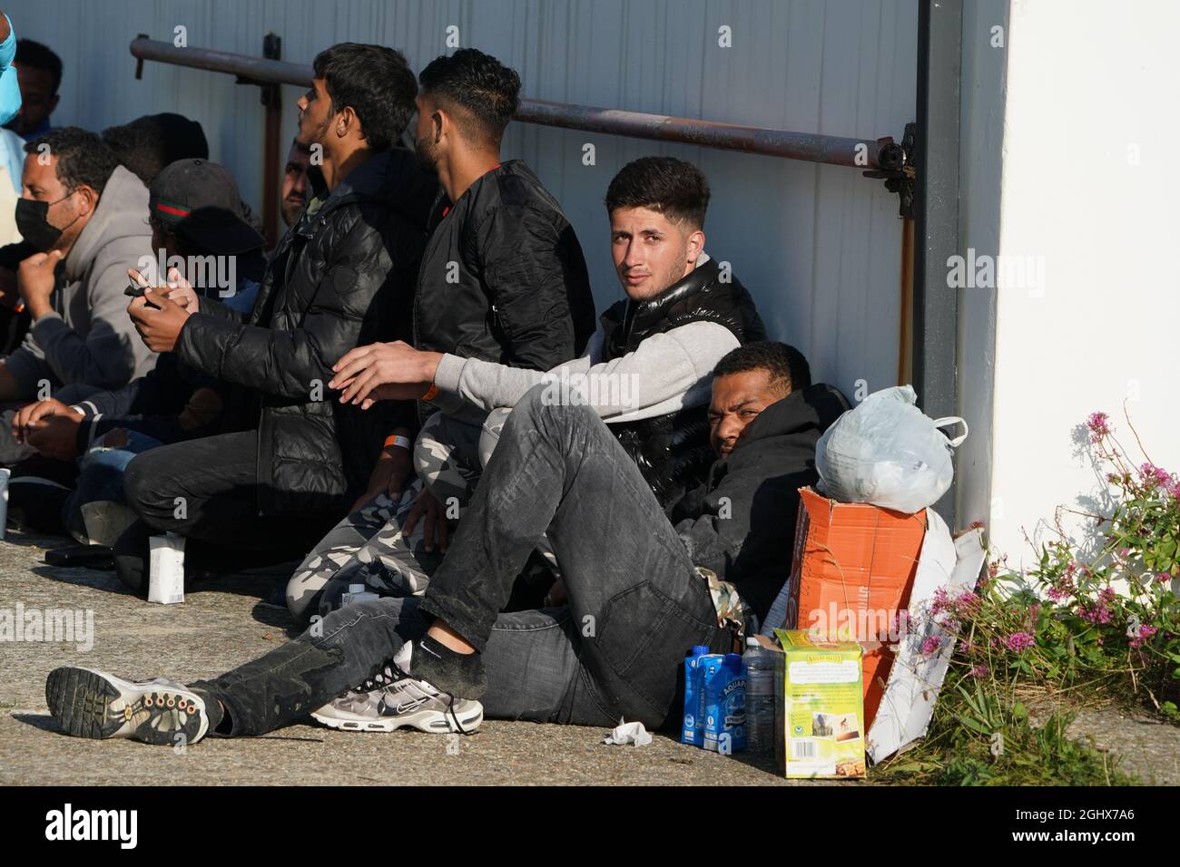 A group of people thought to be migrants wait to be processed by Border ...