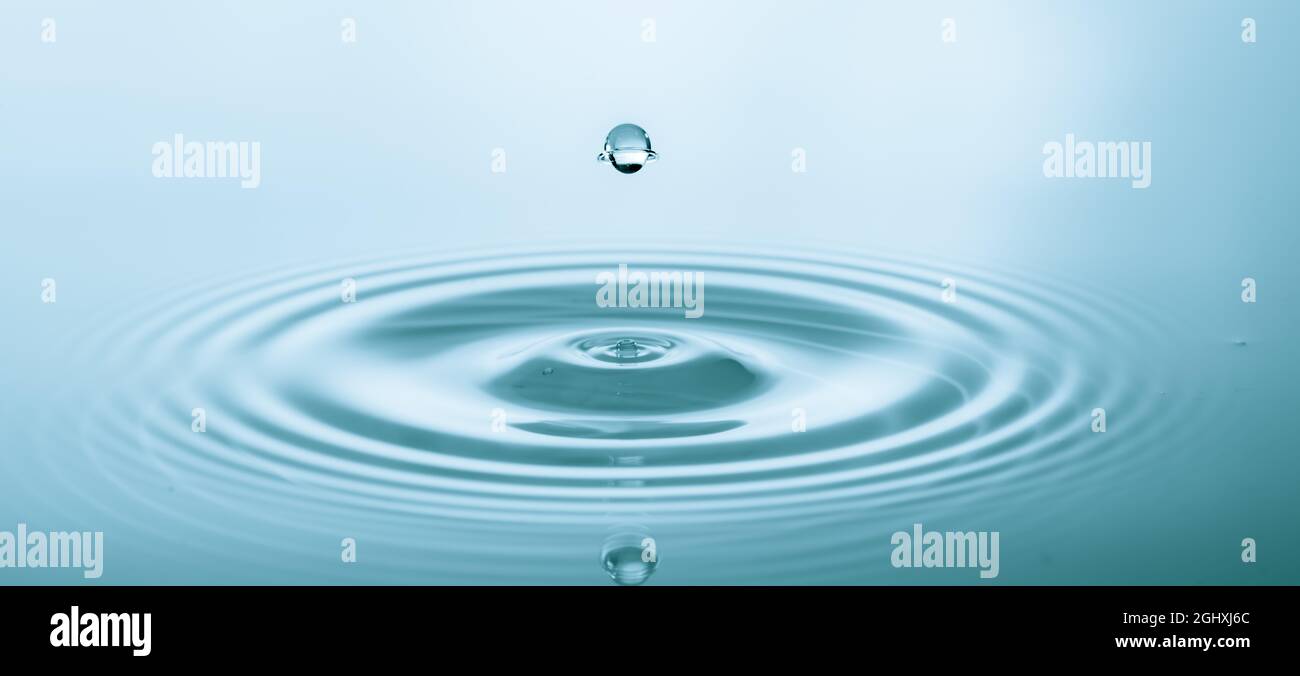 Splash of water droplets on a smooth water surface Stock Photo - Alamy